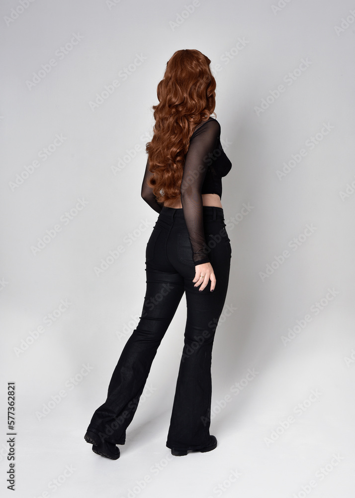Full length portrait of beautiful woman with long red hair wearing ...