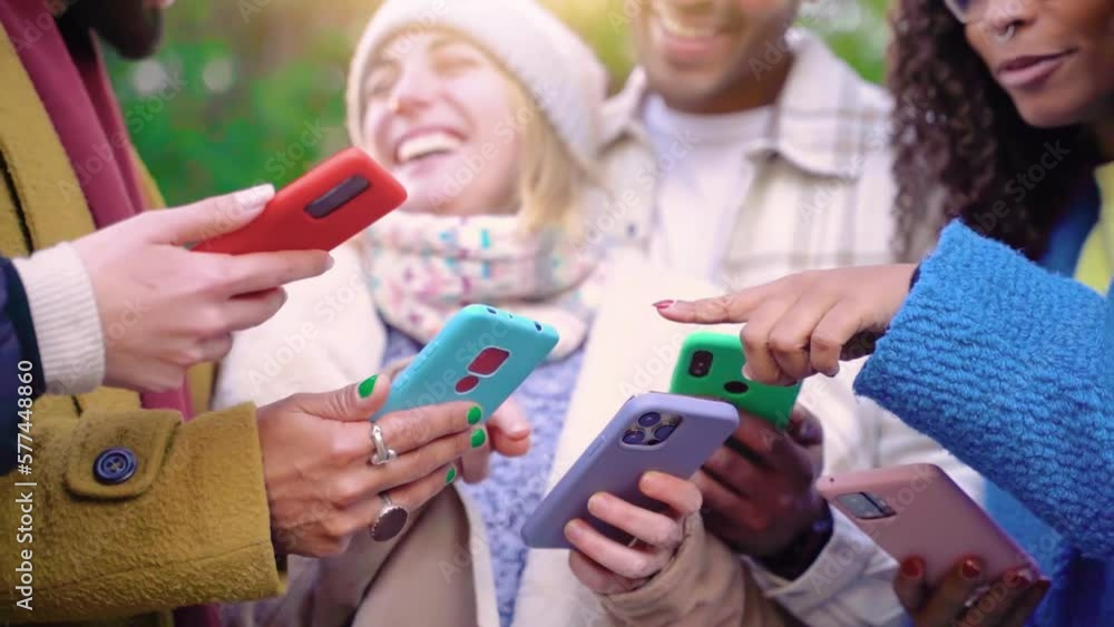 Group of young teenagers friends using cell phones and walking in the ...