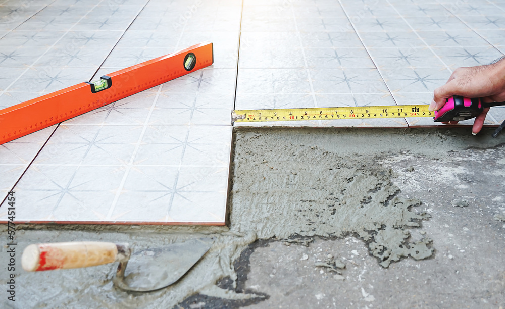 Installation of ceramic floor tiles, Workers are measuring to install ...