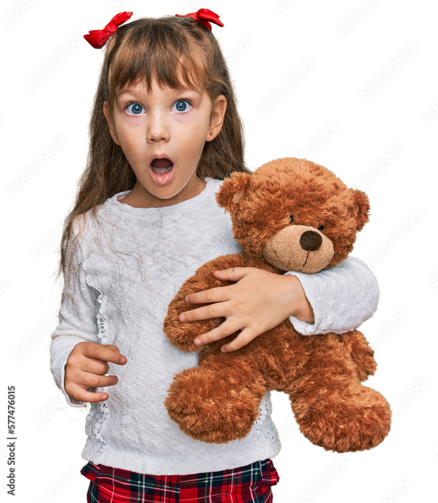 Little caucasian girl kid hugging teddy bear stuffed animal scared and ...