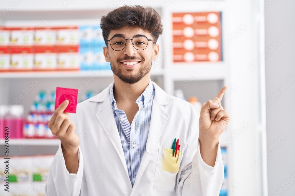 Arab man with beard working at pharmacy drugstore holding condom angry ...