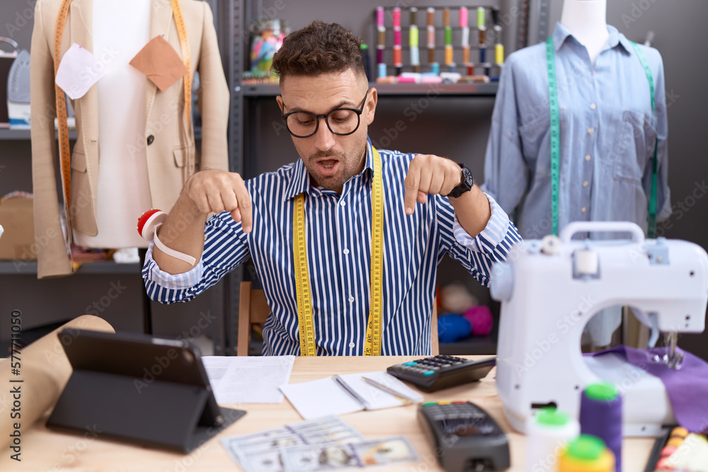 Hispanic man with beard dressmaker designer working at atelier pointing ...