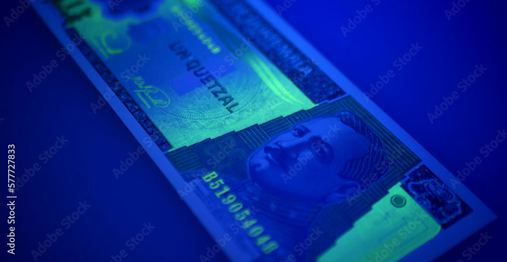 Guatemalan banknotes under UV light. Checking for counterfeit money ...