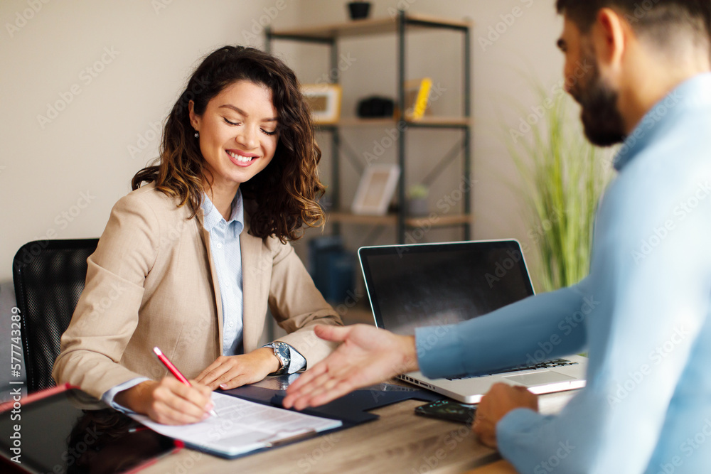 Young woman signing contracts with a manager Stock Photo | Adobe Stock