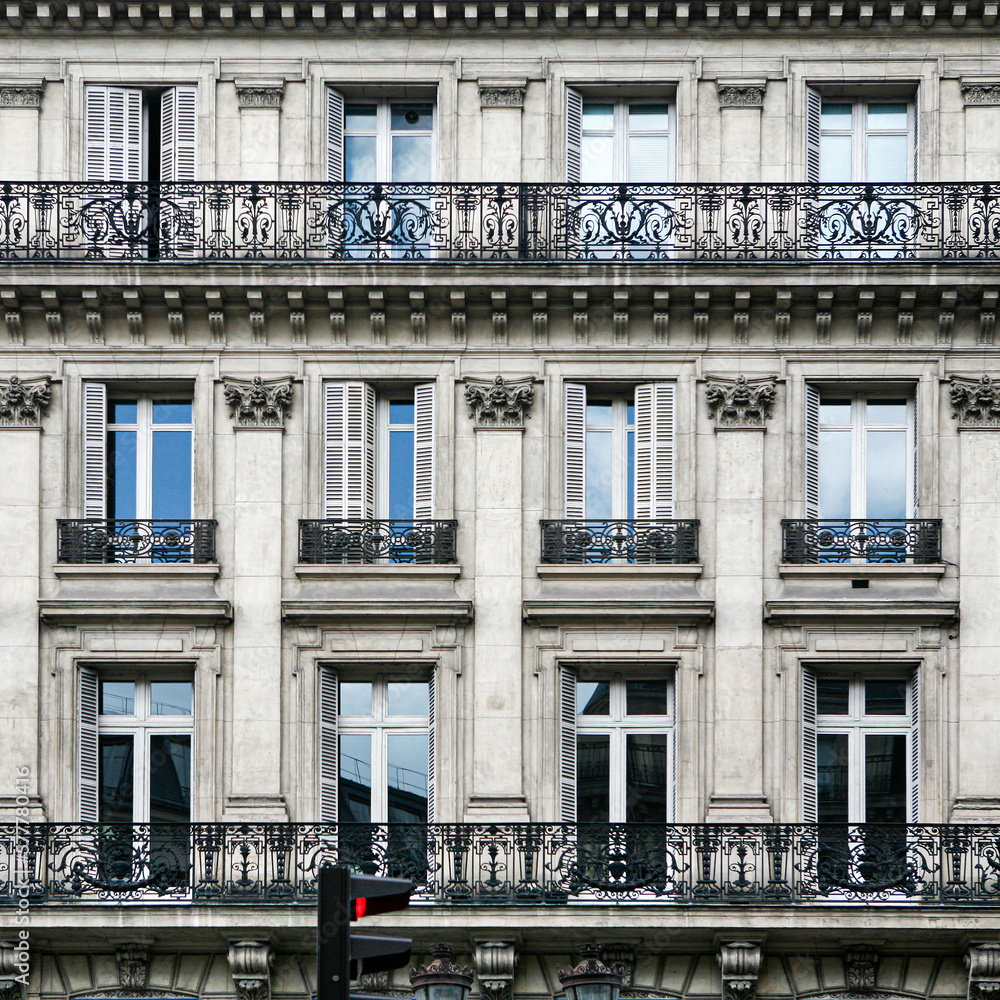 Paris ancient stone building facade with three rows of French windows ...