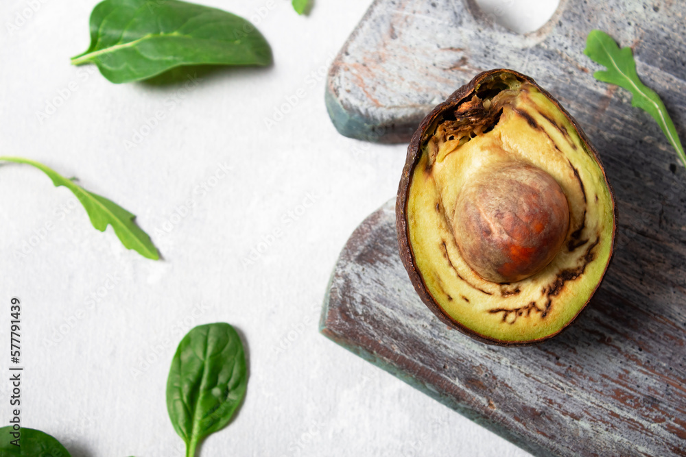 Rotten avocado, overriped, bad avocado. Half sliced fruit on cutting ...