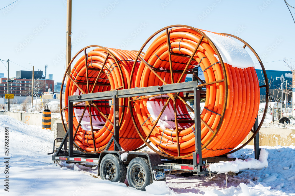 Large spools of smooth walled HDPE plastic cable (orange) conduit on ...