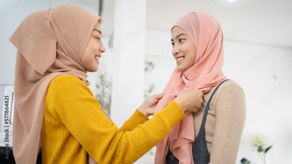 Happy smiling muslim woman help dressing up her friend, concept of ...