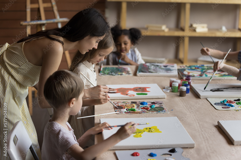 Multiethnic group of kids drawing cartoon animals on canvas, training ...