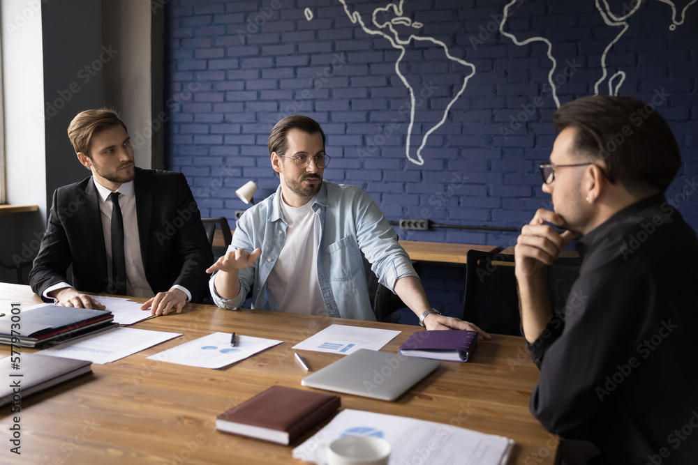 Three serious business partner men negotiating on work project at ...
