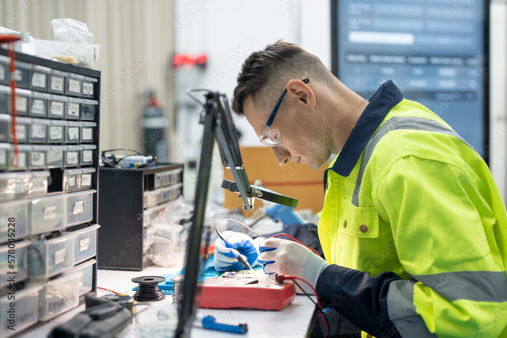 Male electrical engineer using digital multimeter checking voltage on ...