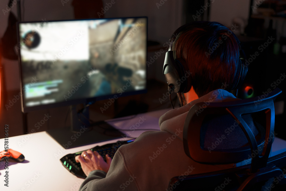 Back view high angle of male cybersport gamer in modern headset using ...