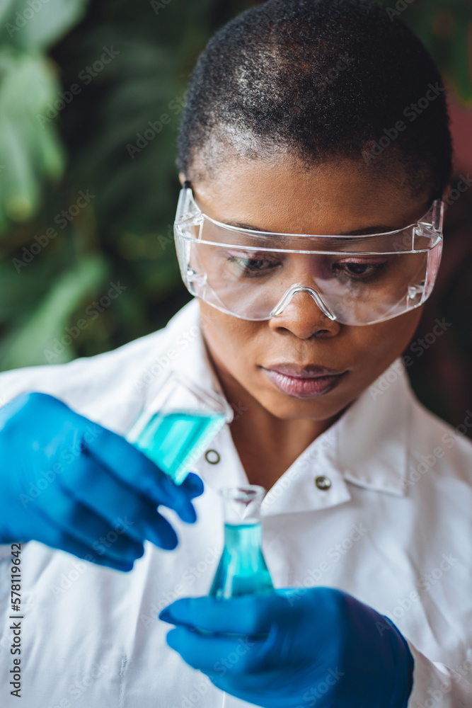 African American female scientist is working in laboratory, making test ...