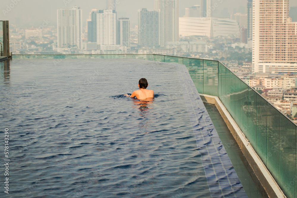 Teenage boy is swimming in the infinity pool in Thailand Stock Photo | Adobe Stock