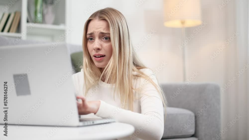Nervous stressed young blond woman freelancer typing quickly on laptop ...