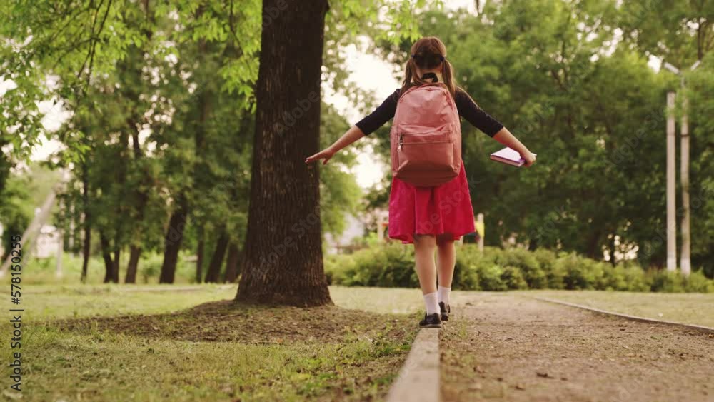 girl kid schoolgirl with school backpack her back walks through park ...