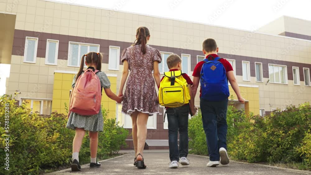 young nanny leads children school. happy family. cheerful children go ...