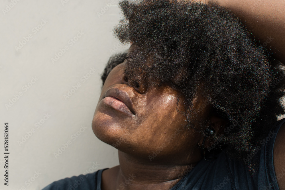 Foto de A woman with imperfect skin. full lips and an afro basking in ...
