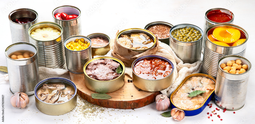 Canned vegetables, beans, fish and fruits in tin cans on a white ...