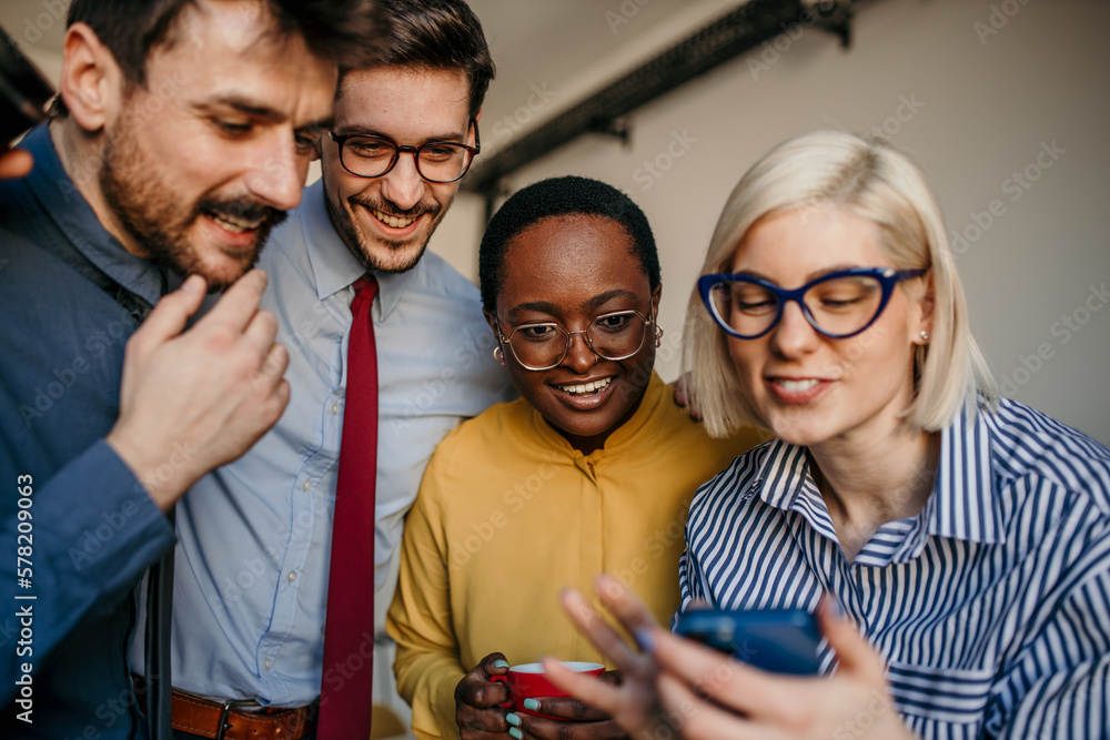 Young group of friends relaxing in a café, drinking coffee and scrolling through social media ...