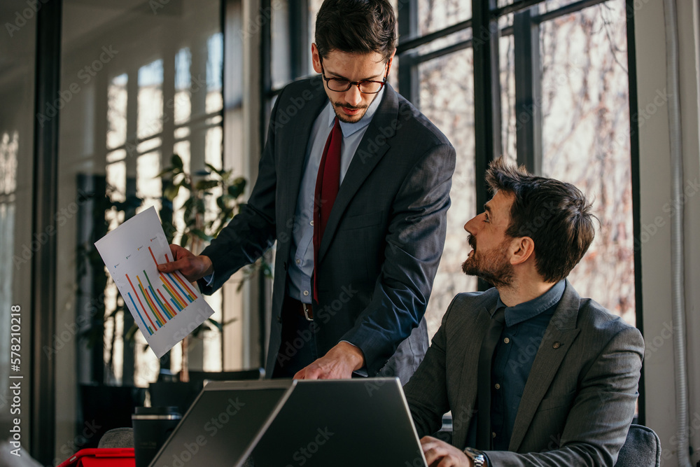 Image of a mid adult manager having a brief meeting with his young ...