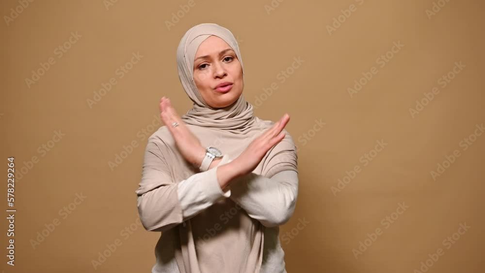 Middle-aged confident Middle-Eastern Muslim woman, dressed in beige ...