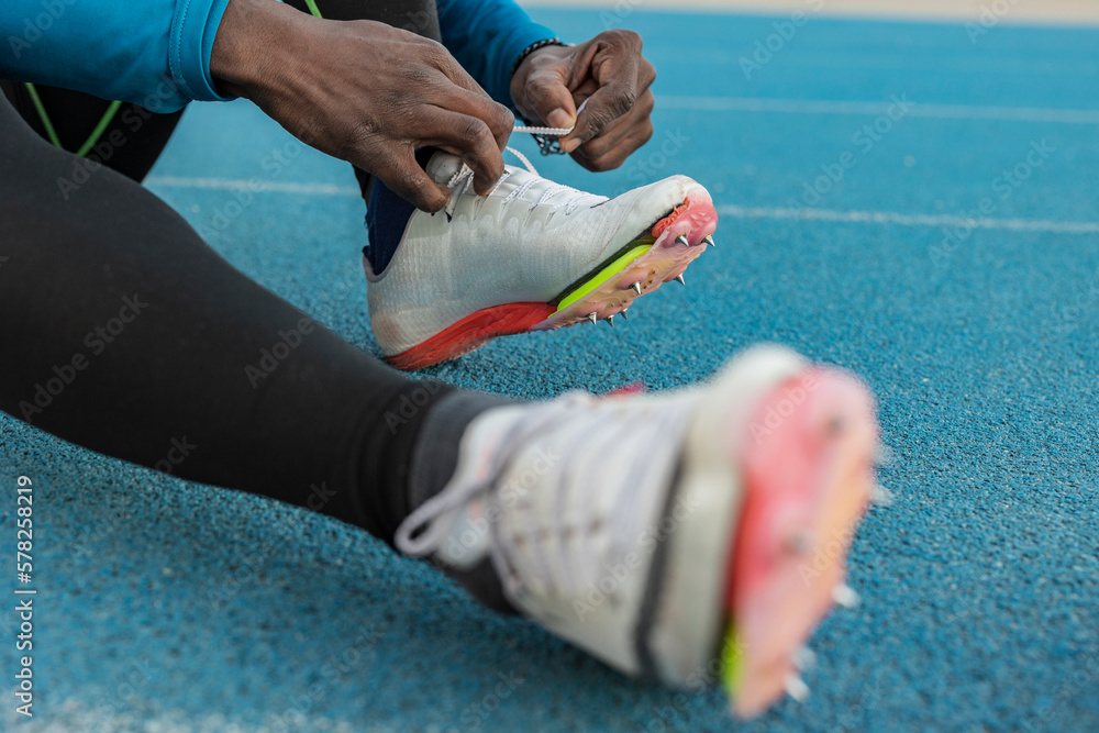 Athlete tying shoes on sports track Stock Photo | Adobe Stock