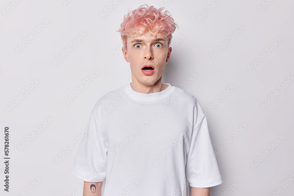 Portrait of astonished pink haired man keeps mouth widely opened cannot ...