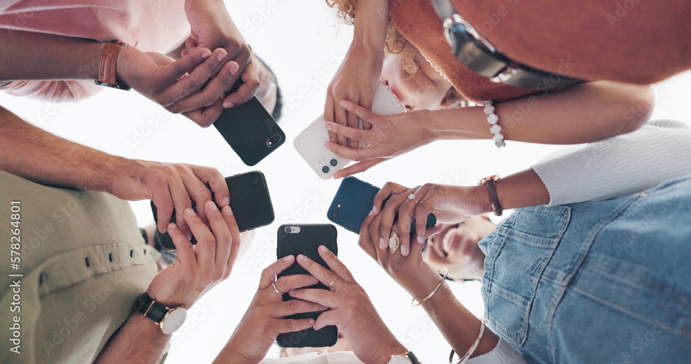 Hands, phone and communication with friends standing in a huddle or ...