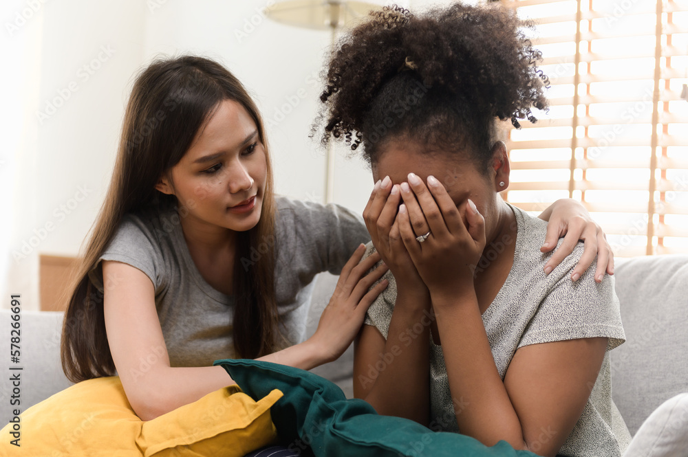 Multi ethnic young woman friend consoling her crying African ethnic ...