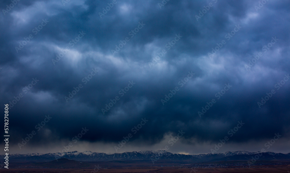 Rain clouds over a mountain range in the distance. Change of weather in ...