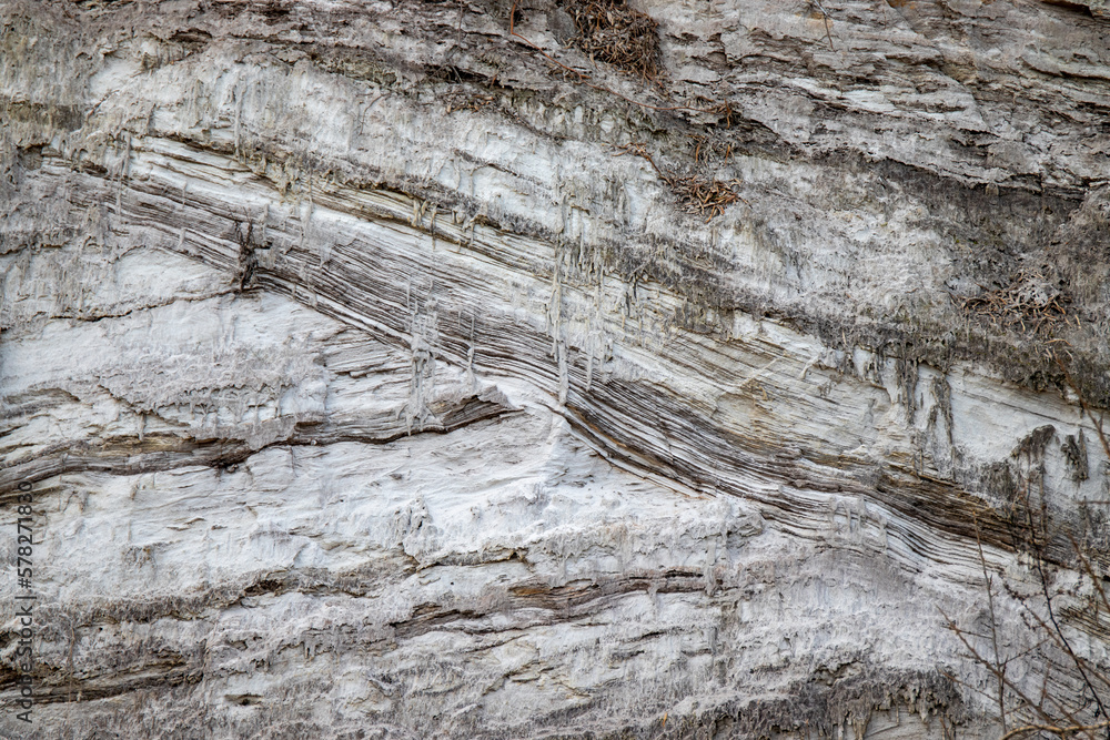 Layered texture of a high shore being eroded by the sea, creating a ...