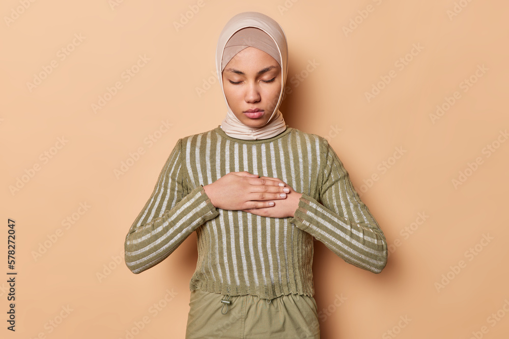 Stockfoto Calm Arabian Muslim woman wears traditional hijab presses ...