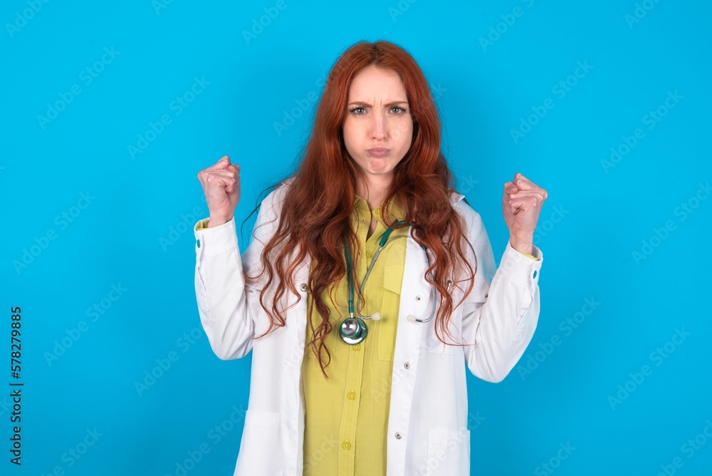 Irritated young doctor woman wearing medical uniform over blue ...