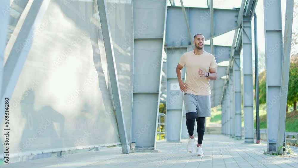 Young adult mixed race runner jogging on the street in the city. A ...
