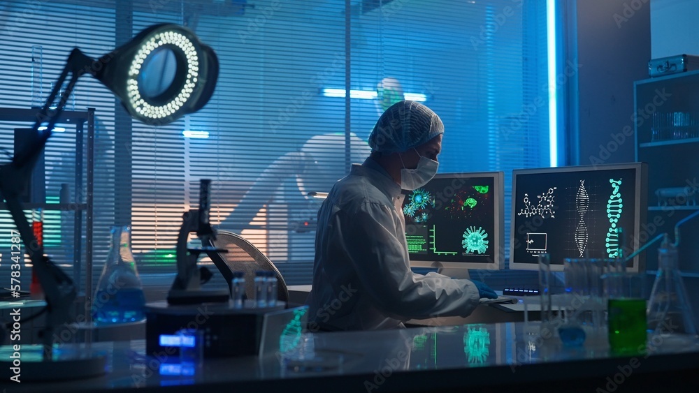 Medical development laboratory. A male scientist types on a keyboard ...