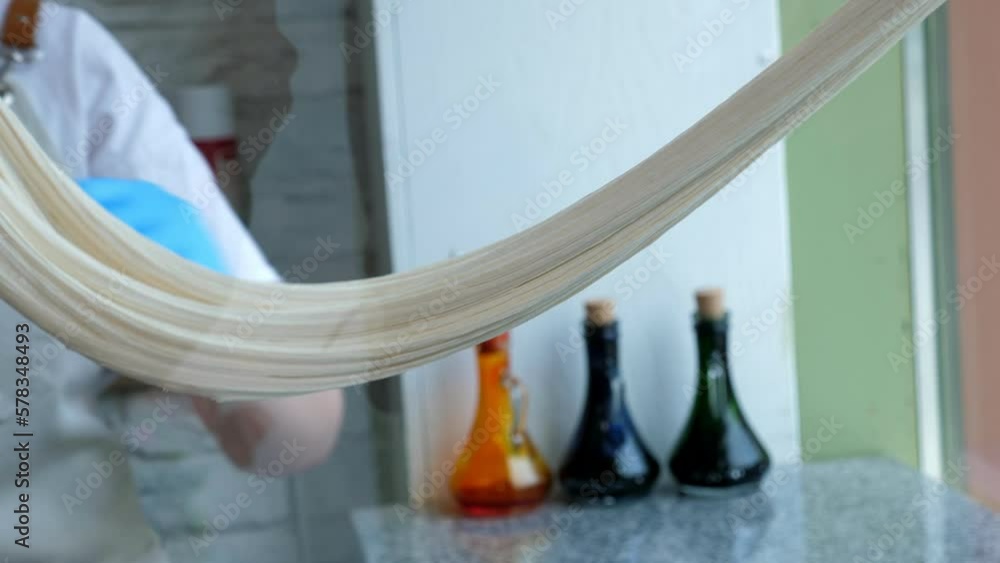 Close-up of a female pastry chef mixing and stretching liquid white ...