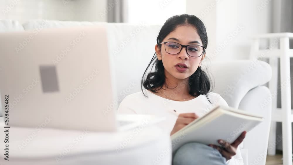 Portrait of focused indian girl preparing for exam and studying at home ...