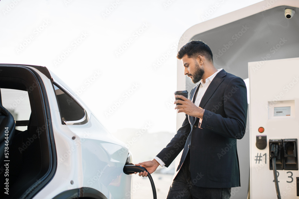 Side view of handsome arabian man in formal outfit holding coffee-to-go ...