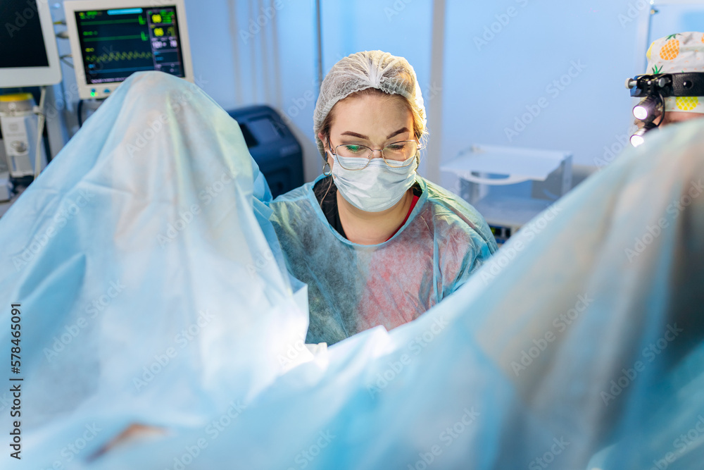 Professional female surgeon proctologist performing operation using ...