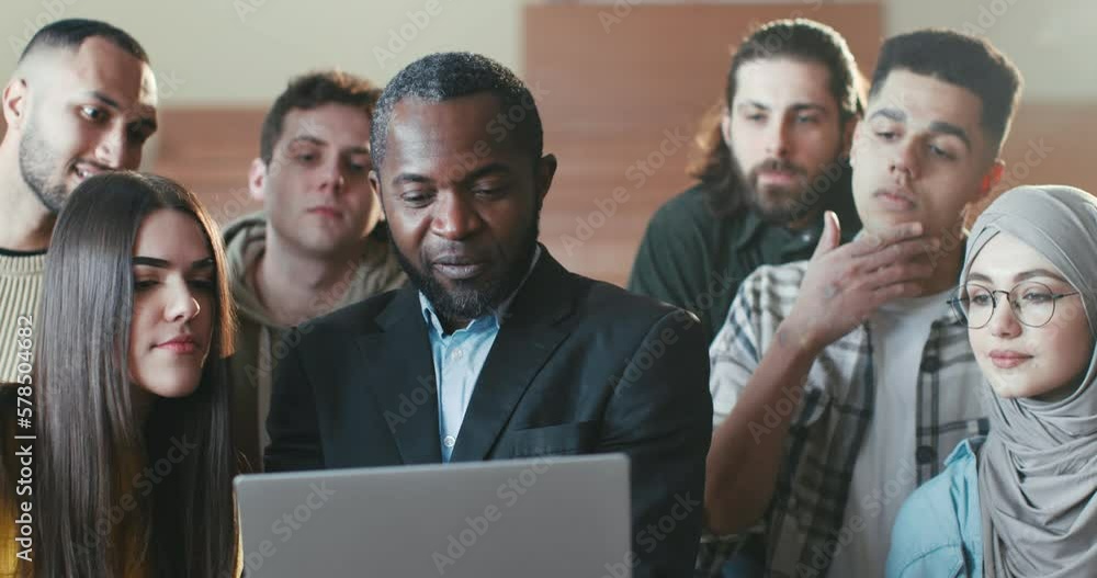 Close up of male African American professor with laptop talking with ...