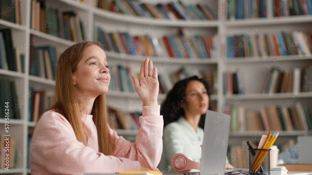 Young smart woman student raising hand and answering professors ...