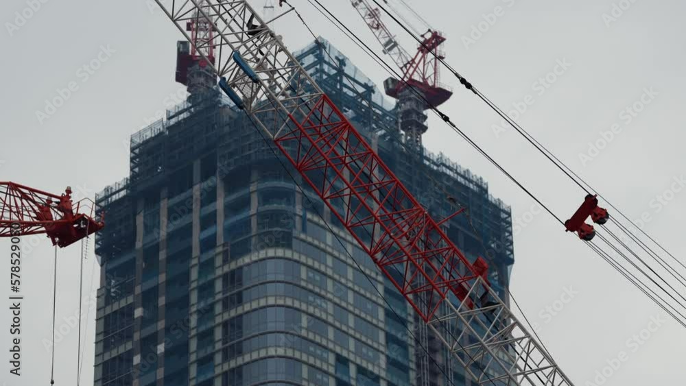 Skyscraper building under construction. 4K video with cranes working on ...