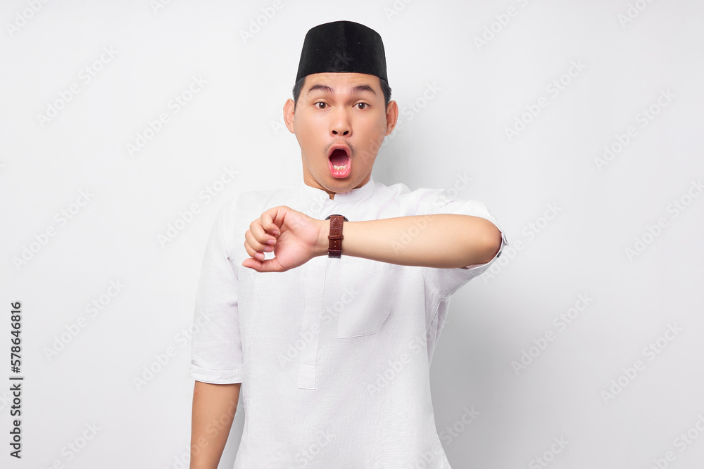 Shocked young Asian Muslim man in Arabic clothes raised his arm and ...
