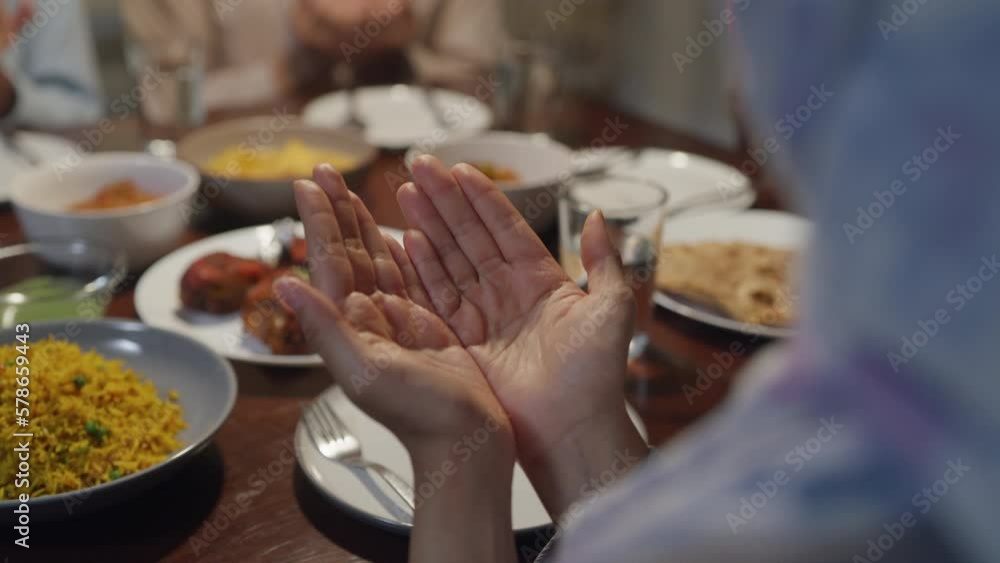 Close-up islam woman hand pray. Happy Asian muslim family praying to god before eating Ramadan ...