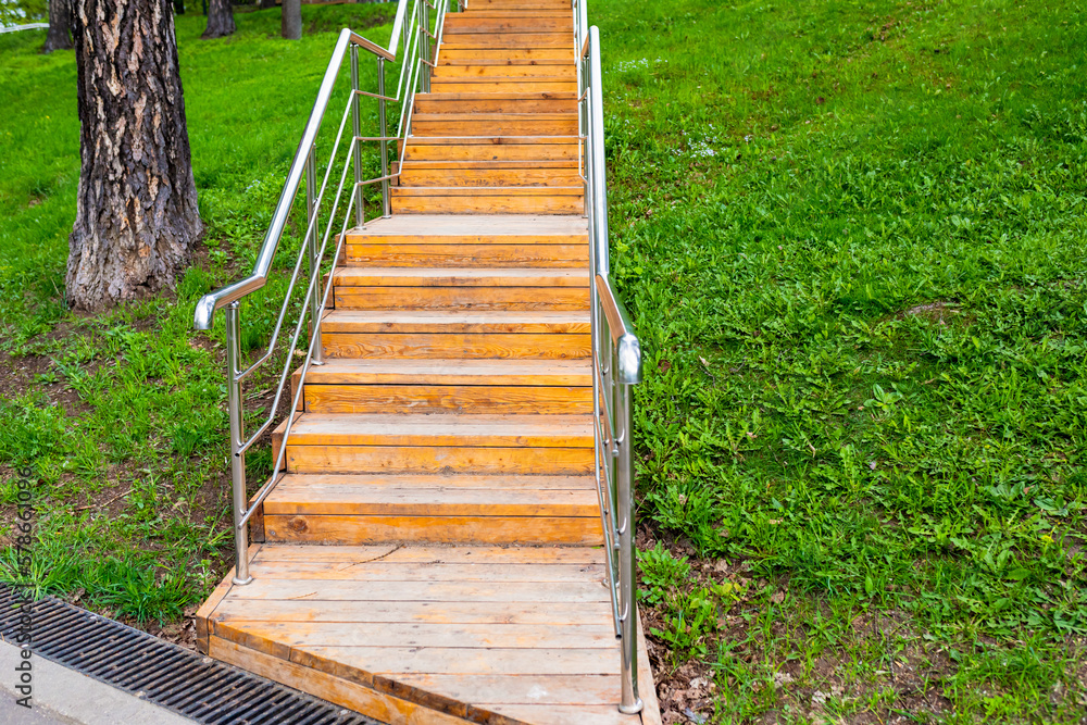 stairs with handrails on both sides in a park. A new wooden staircase ...