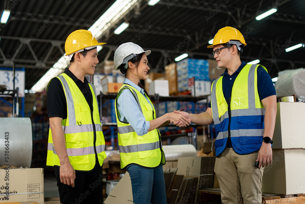 Asian warehouse workers team shaking hands together in the storage ...