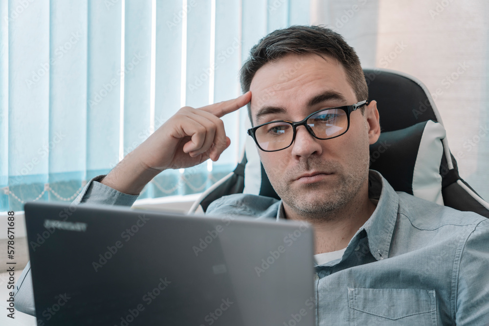 Thoughtful it developer thinking about fixing software bugs on netbook ...