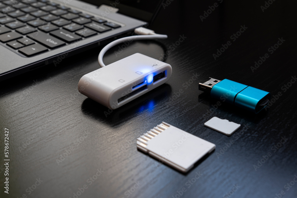 Laptop with USB Type-C adapter with pluged USB cables and SD card. The USB adapter under the ...