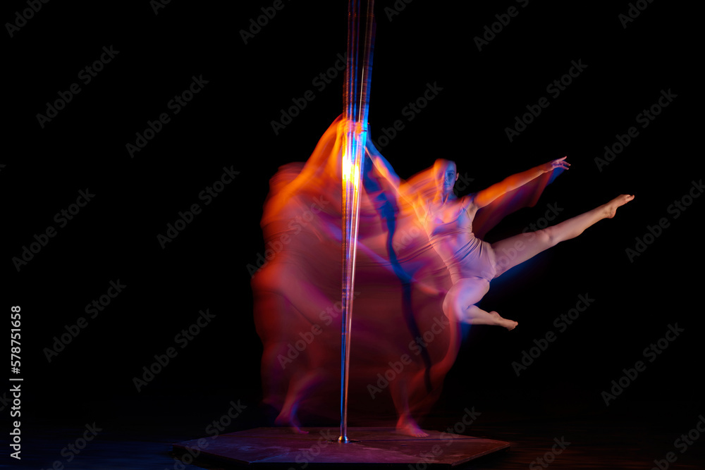 In dynamics, spinning. Young girl performing pole dance isolated over ...